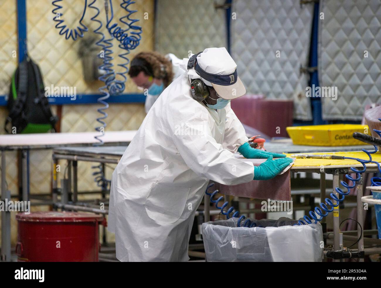 Employees prep materials to be used in construction of overhead storage ...