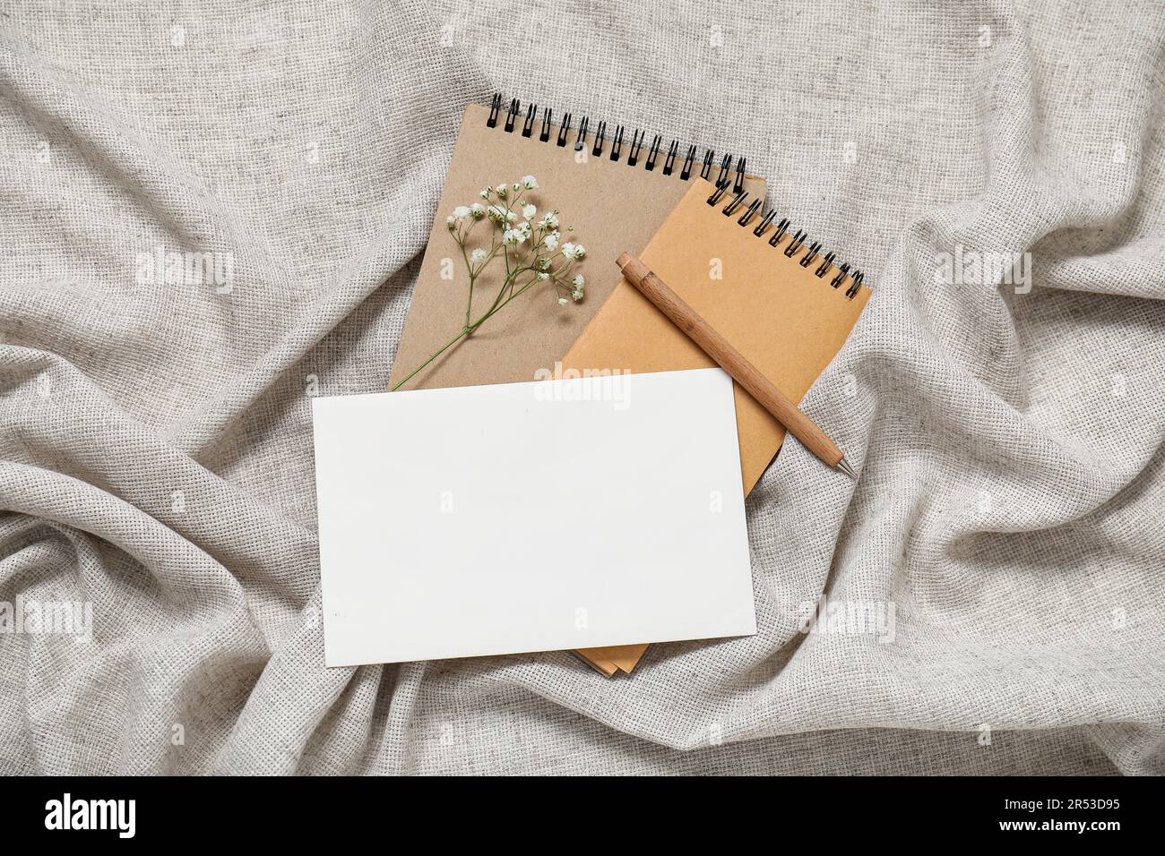 Blank invitation card, notebooks and gypsophila flowers on grey ...