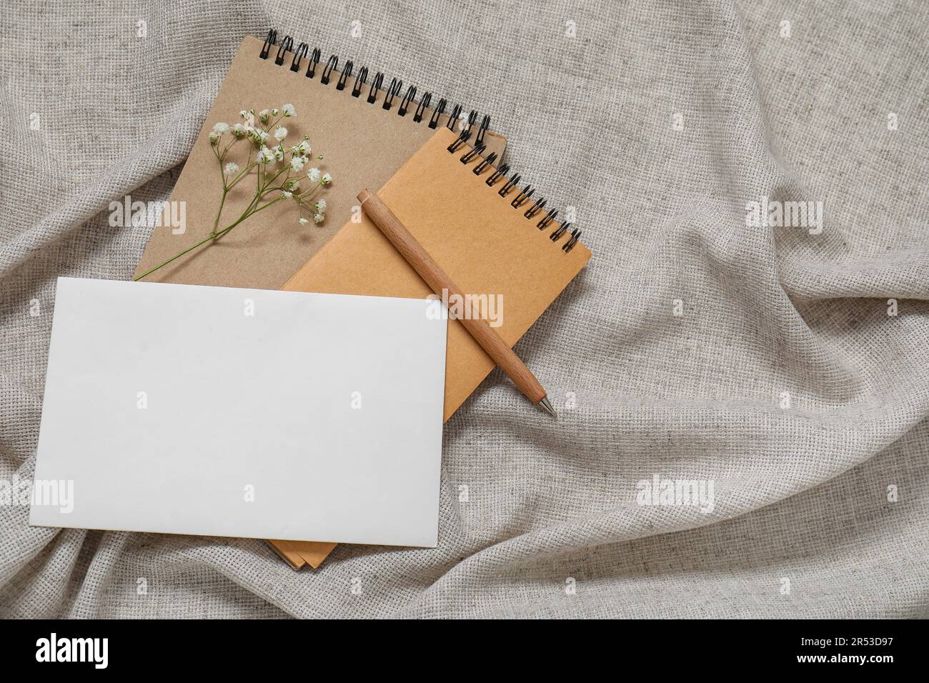 Blank invitation card, notebooks and gypsophila flowers on grey ...
