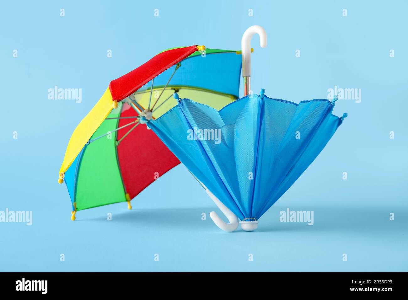 Colorful mini umbrellas on blue background Stock Photo - Alamy