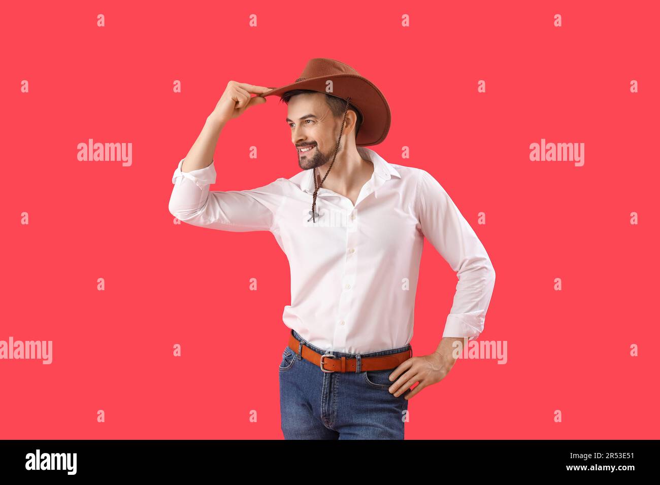 Handsome cowboy on red background Stock Photo - Alamy