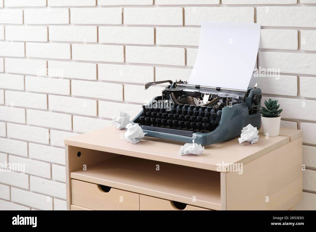 Vintage typewriter with crumpled paper and houseplant on table near ...