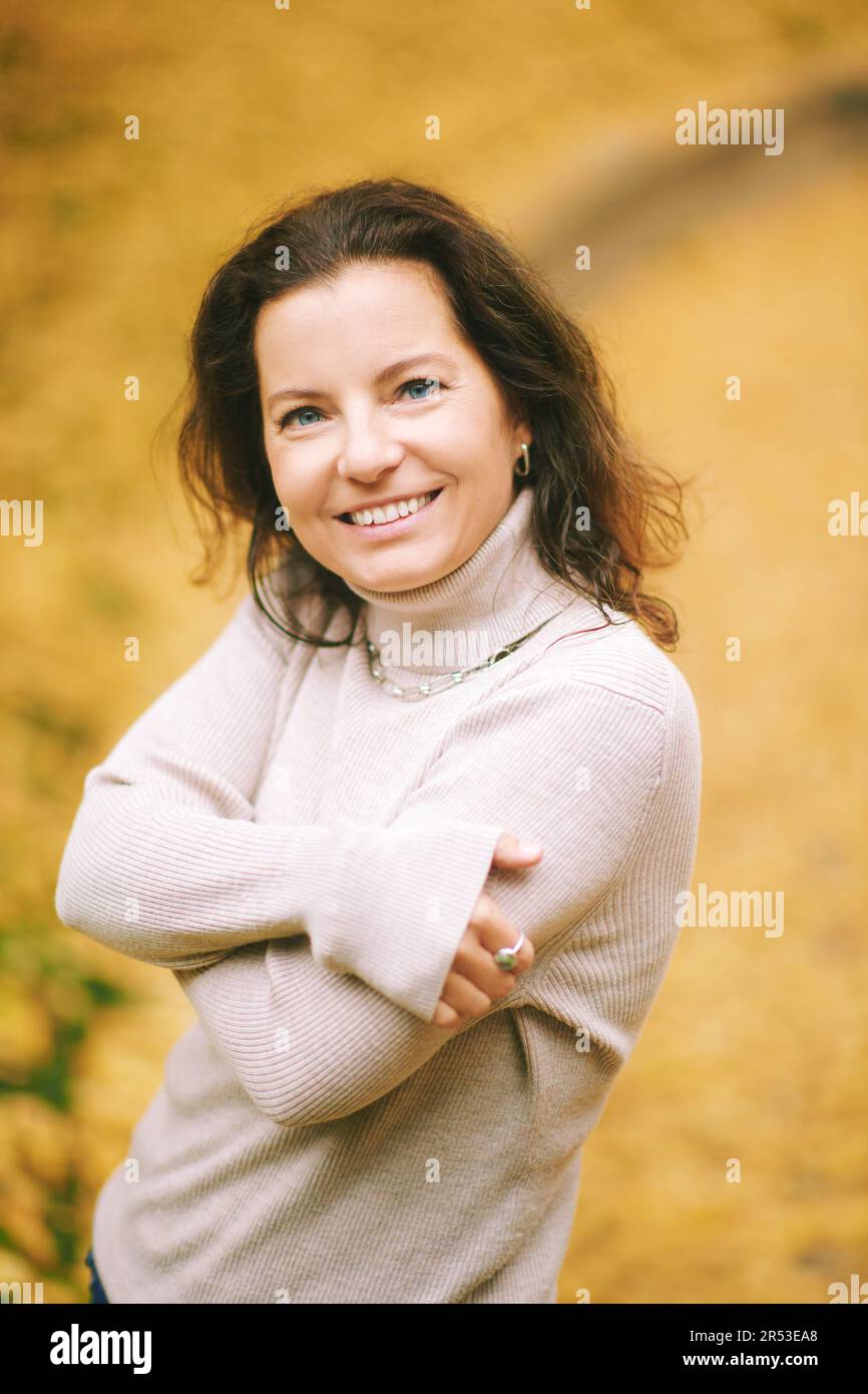 Autumn Portrait Of Beautiful Mature Woman Posing On Yellow Background