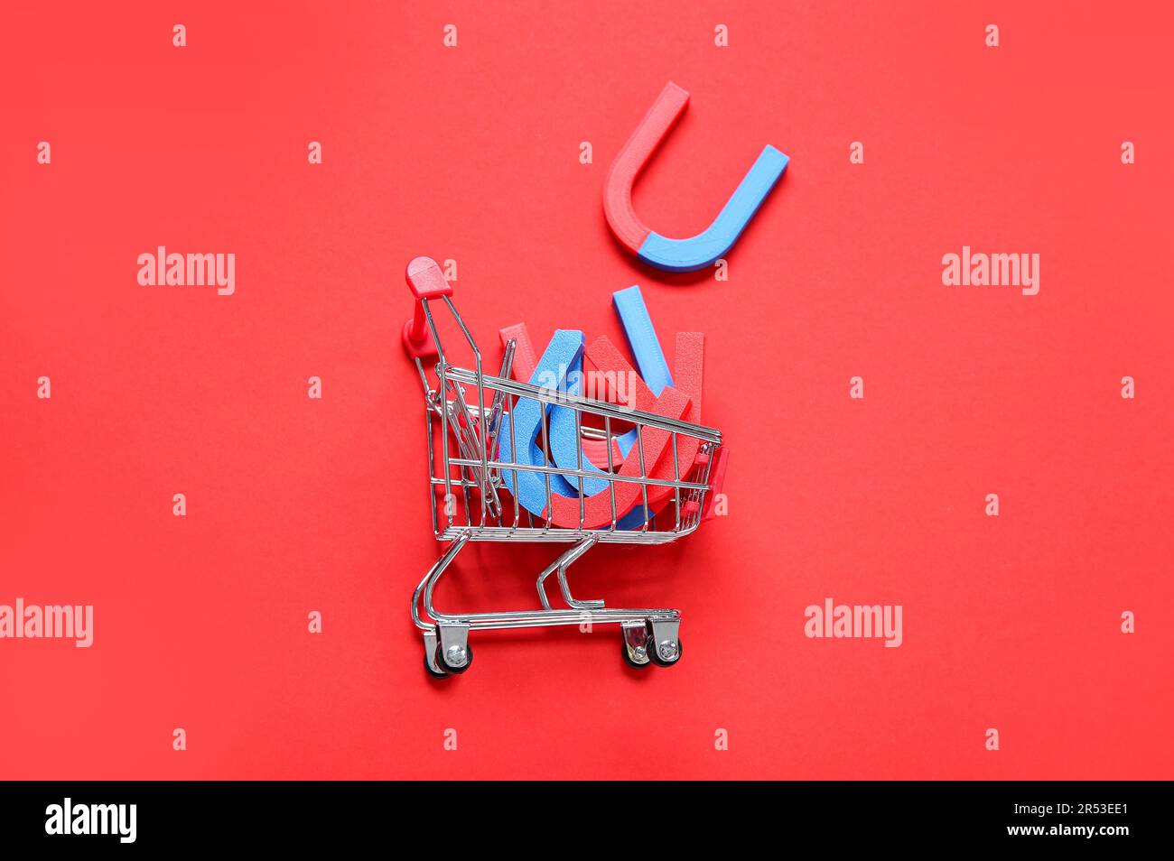 Mini trolley with magnets on red background Stock Photo - Alamy
