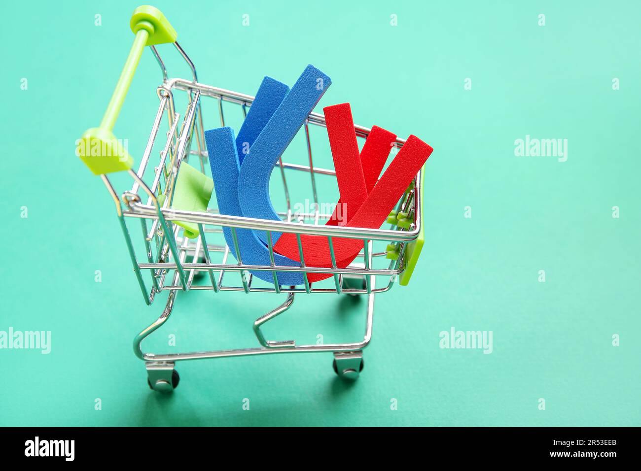 Mini trolley with magnets on green background Stock Photo - Alamy