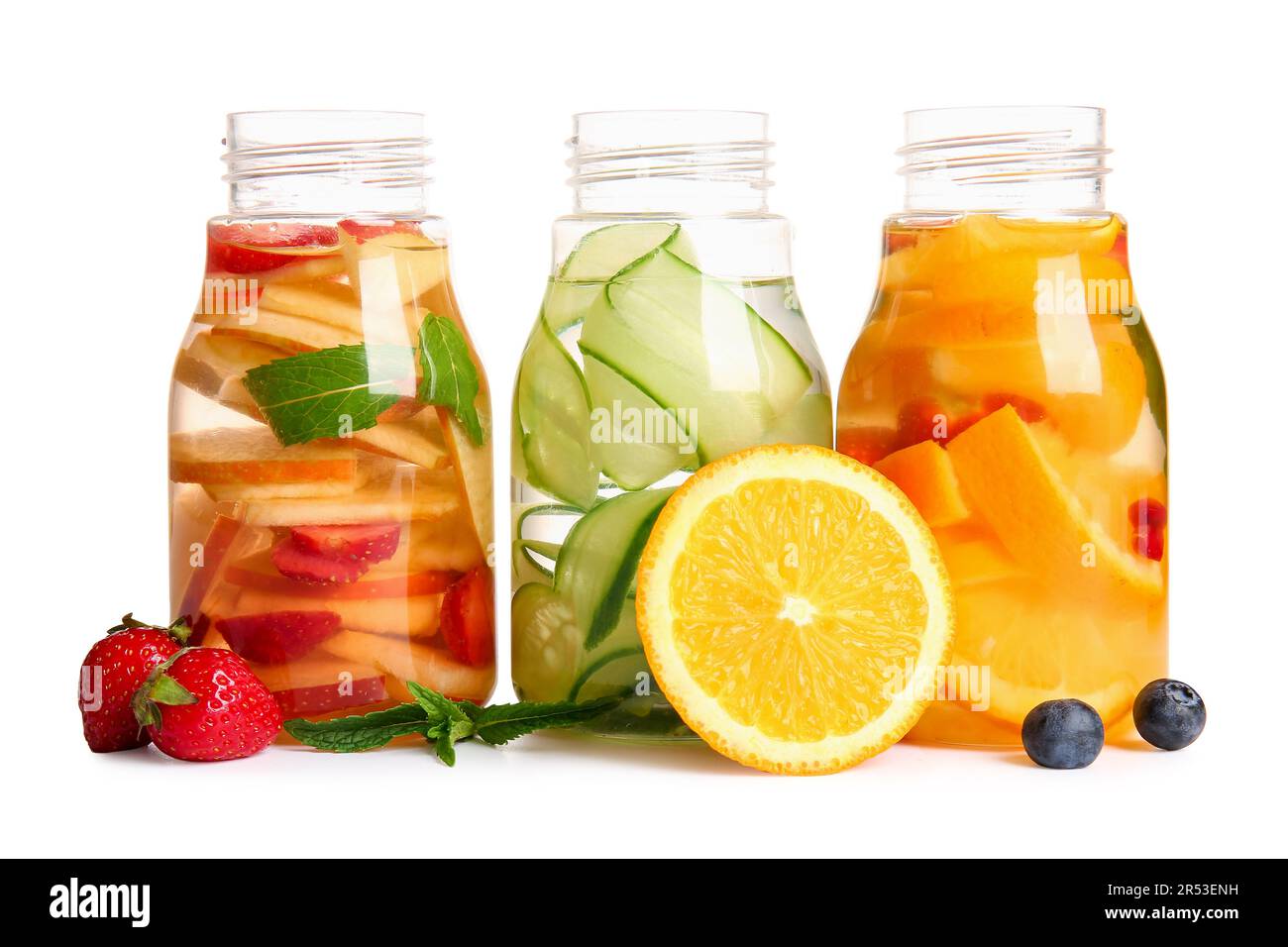 Bottles of infused water with different sliced fruits on white ...
