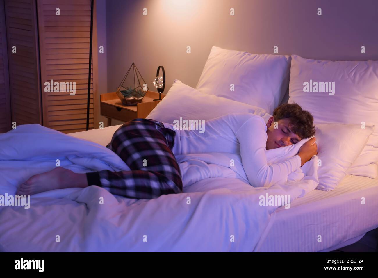 Young man sleeping in bed at night Stock Photo - Alamy