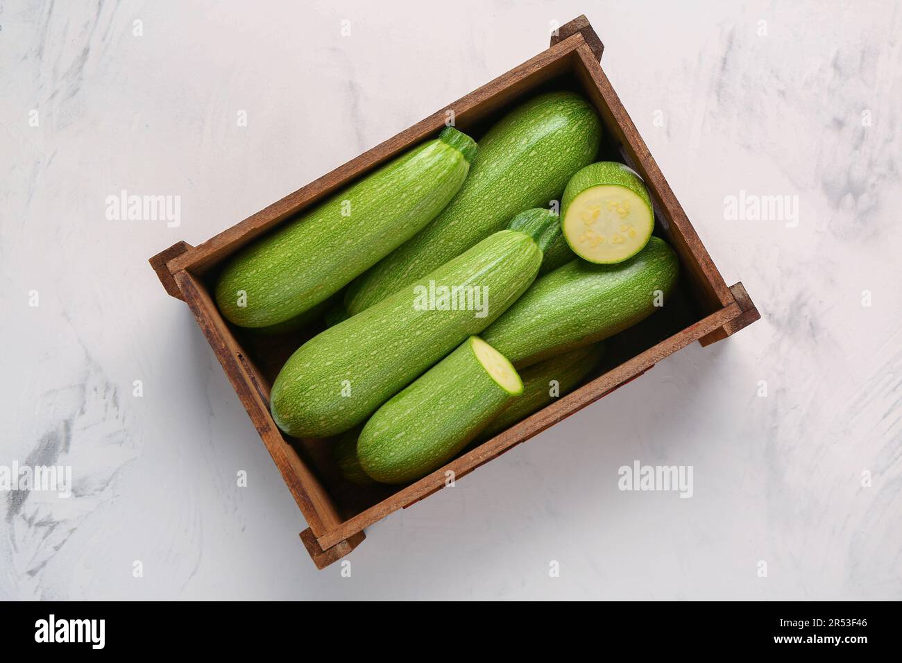 Wooden box with fresh green zucchini on white background Stock Photo ...