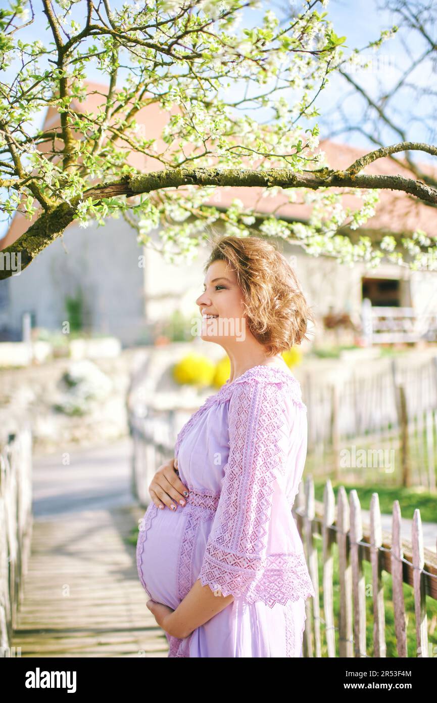 Outdoor portrait of happy pregnant woman enjoying nice sunny day in ...