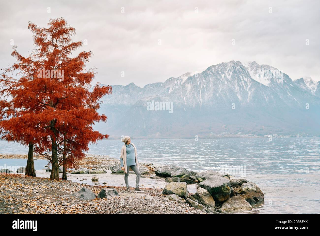 Outdoor portrait of beautiful young woman relaxing by mountain lake ...