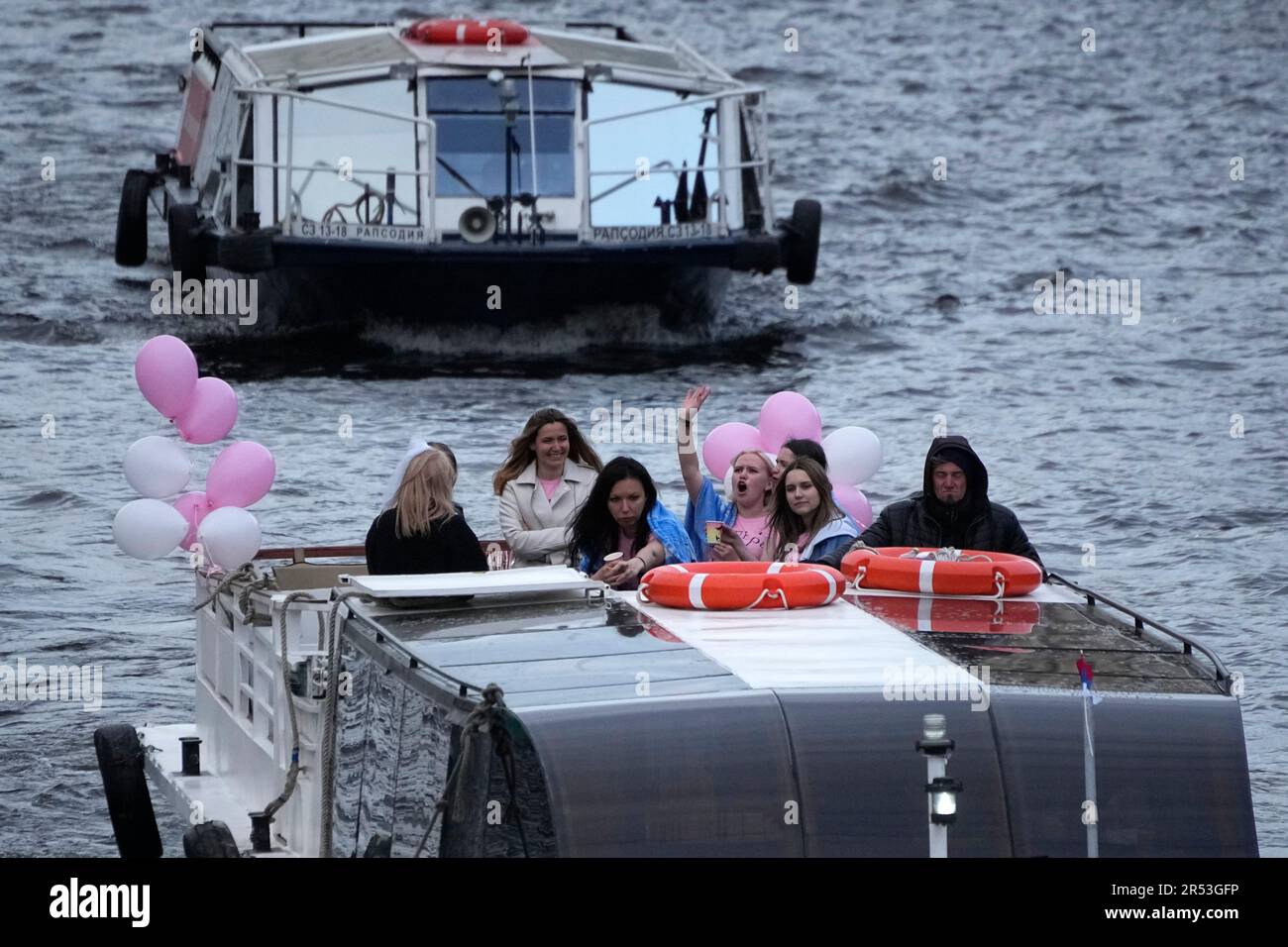 Girls attend a party on a floating boat along Fontanka River in St ...