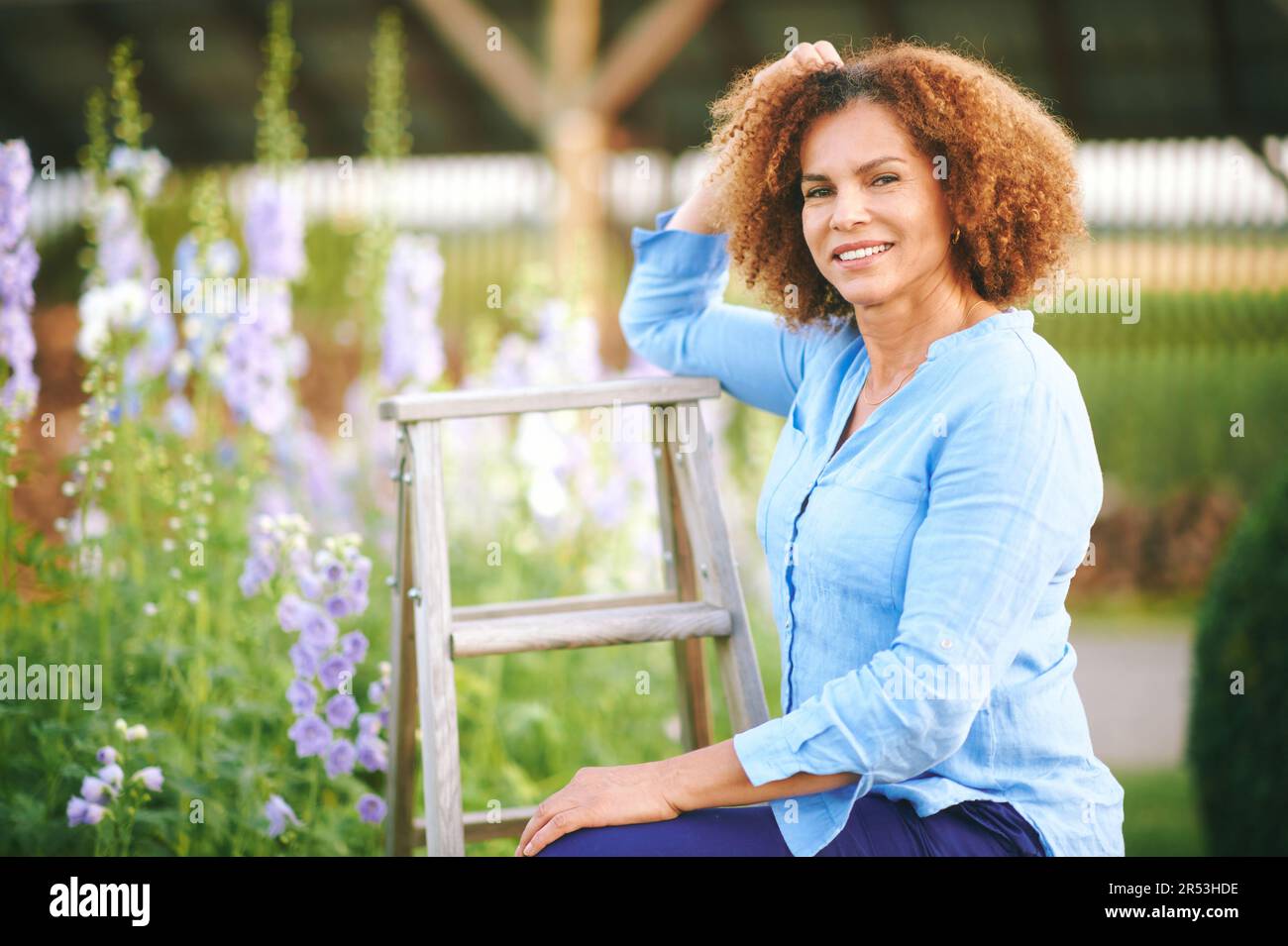 Outdoor portrait of beautiful 50 year old woman enjoying nice day in ...