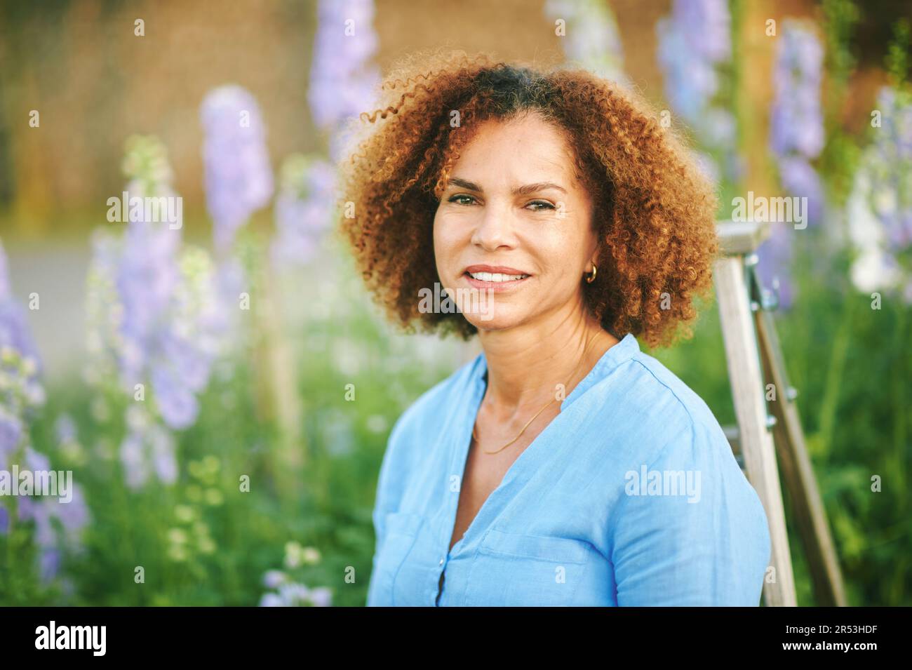 Outdoor portrait of beautiful 50 year old woman enjoying nice day in ...