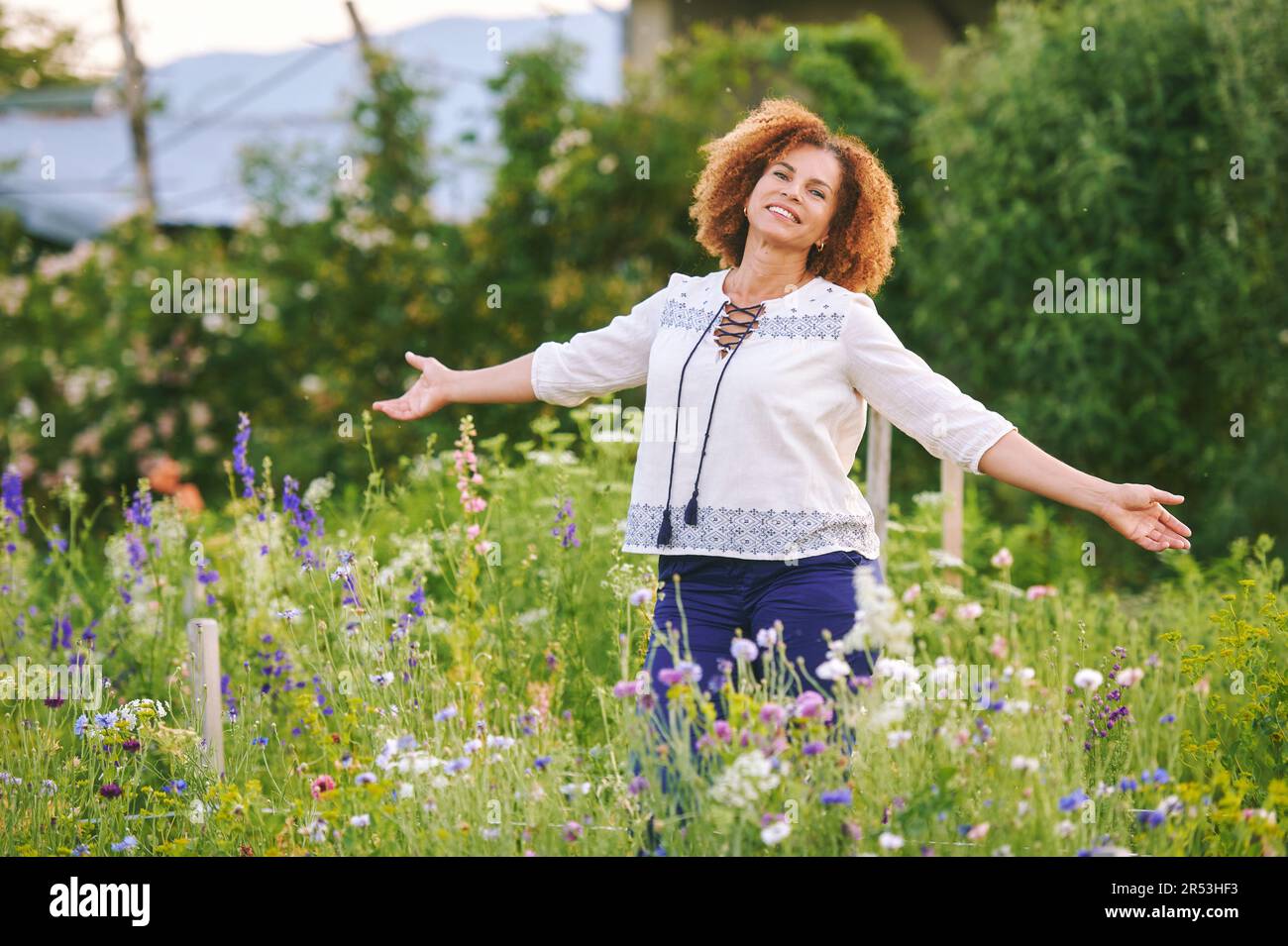 Outdoor portrait of beautiful 50 year old woman enjoying nice day in ...