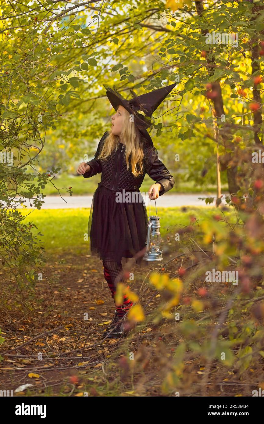 The little witch looks around in fright and walks through the forest ...