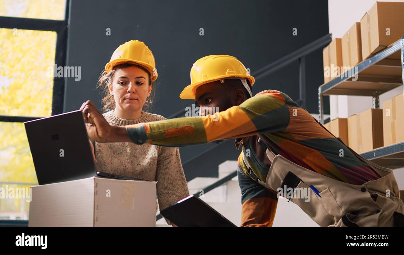 Delivery team review shipment logistics, looking at list of products ...