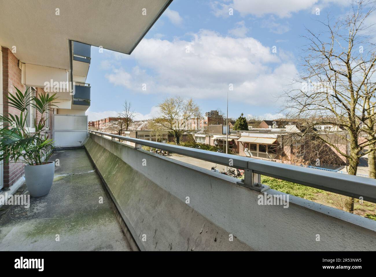 a balcony with trees and buildings in the background, taken from inside ...
