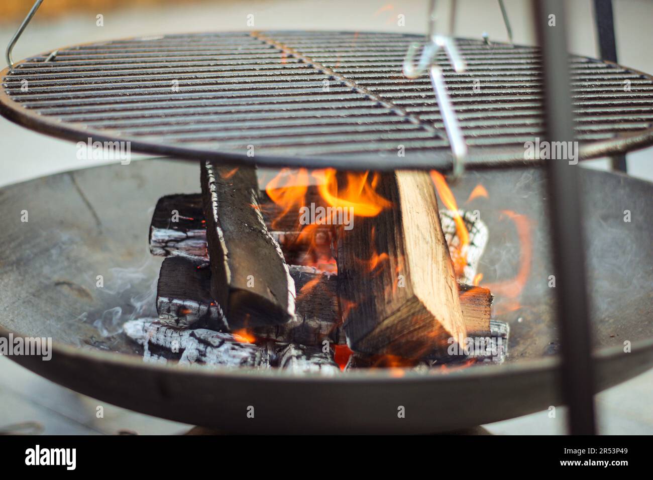 Burning of a campfire to heat up a grill for a barbecue Stock Photo - Alamy