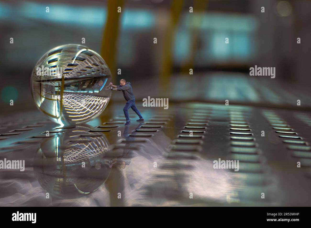 a small person pushing on a crystal ball Stock Photo - Alamy