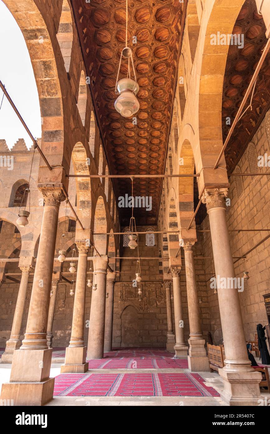 Tall ceilings and arches of an old mosque in Cairo with red carpets ...