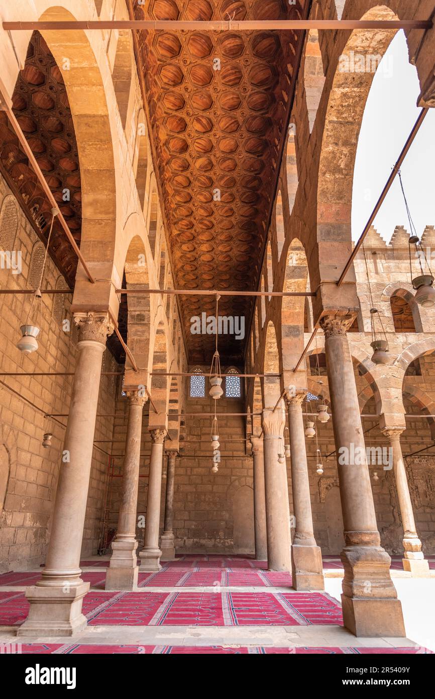 Tall ceilings and arches of an old mosque in Cairo with red carpets ...