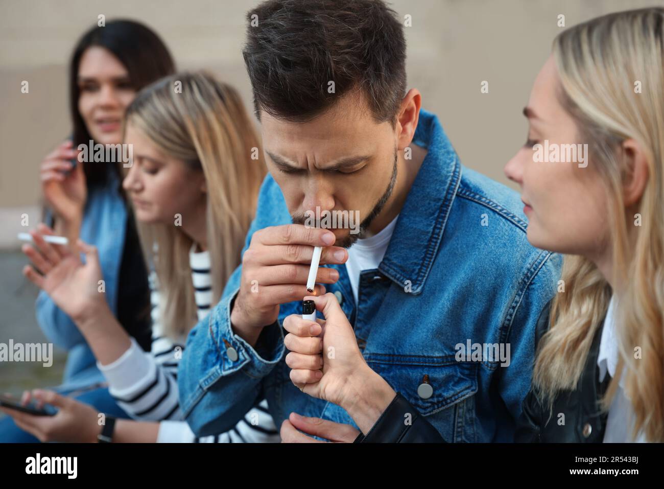 People smoking cigarettes at public place outdoors Stock Photo - Alamy