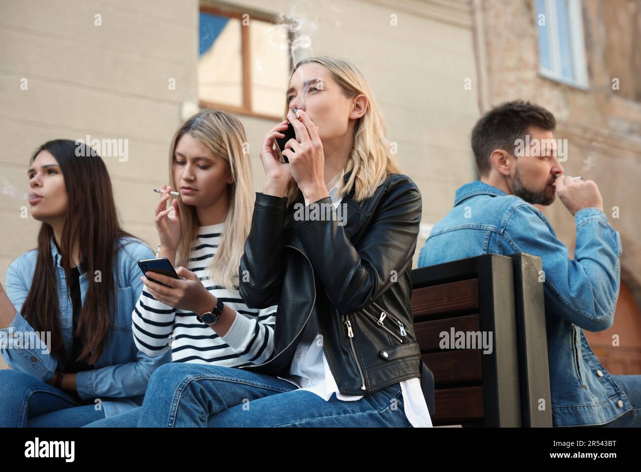 People smoking cigarettes at public place outdoors Stock Photo - Alamy