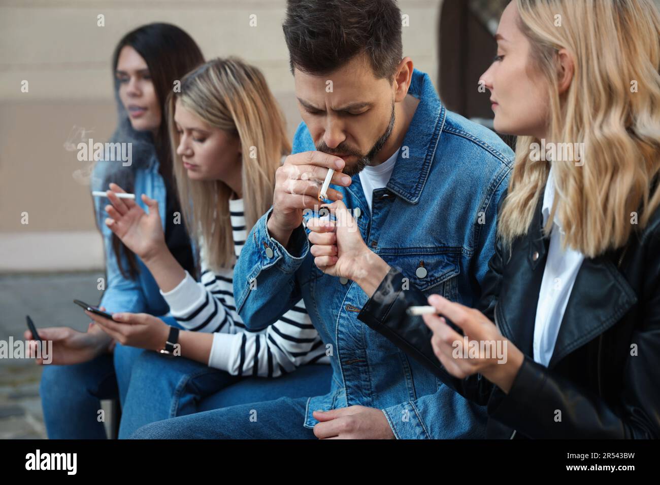 People smoking cigarettes at public place outdoors Stock Photo - Alamy