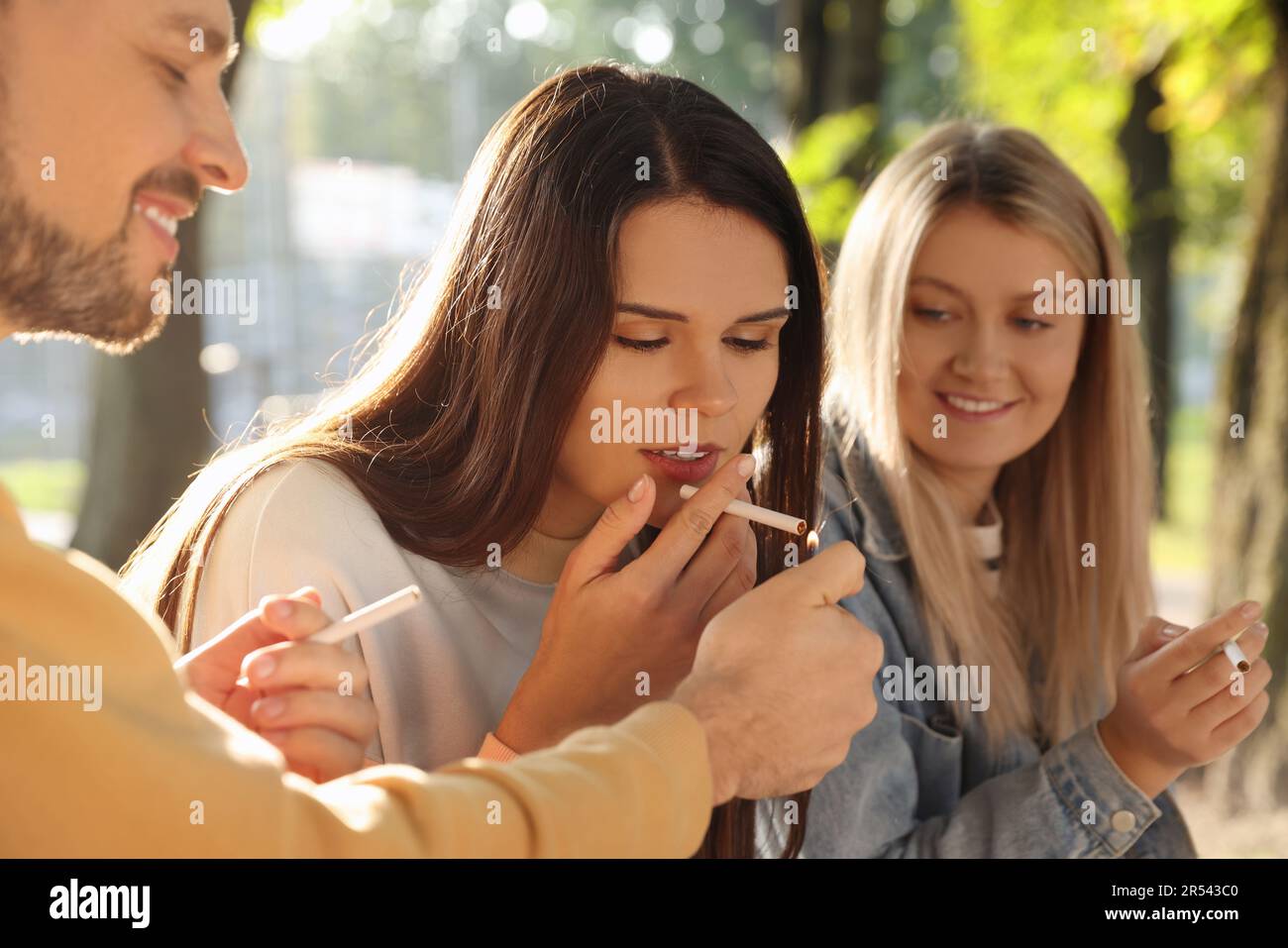People smoking cigarettes outdoors on sunny day Stock Photo - Alamy