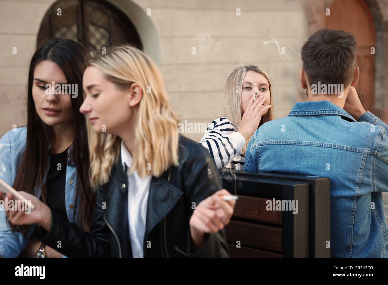 People smoking cigarettes at public place outdoors Stock Photo - Alamy