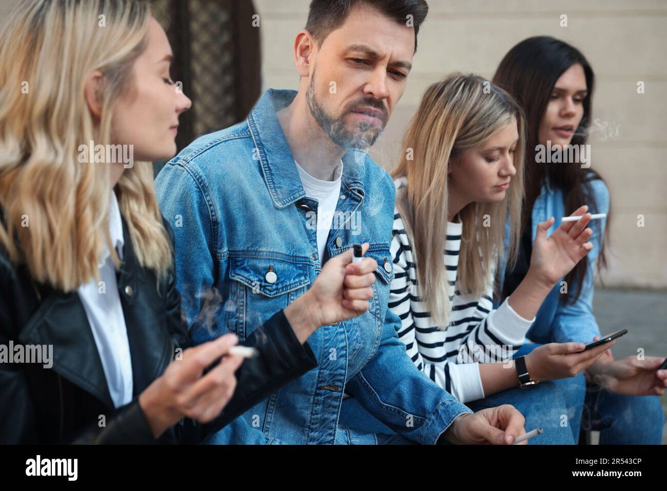 People smoking cigarettes at public place outdoors Stock Photo - Alamy