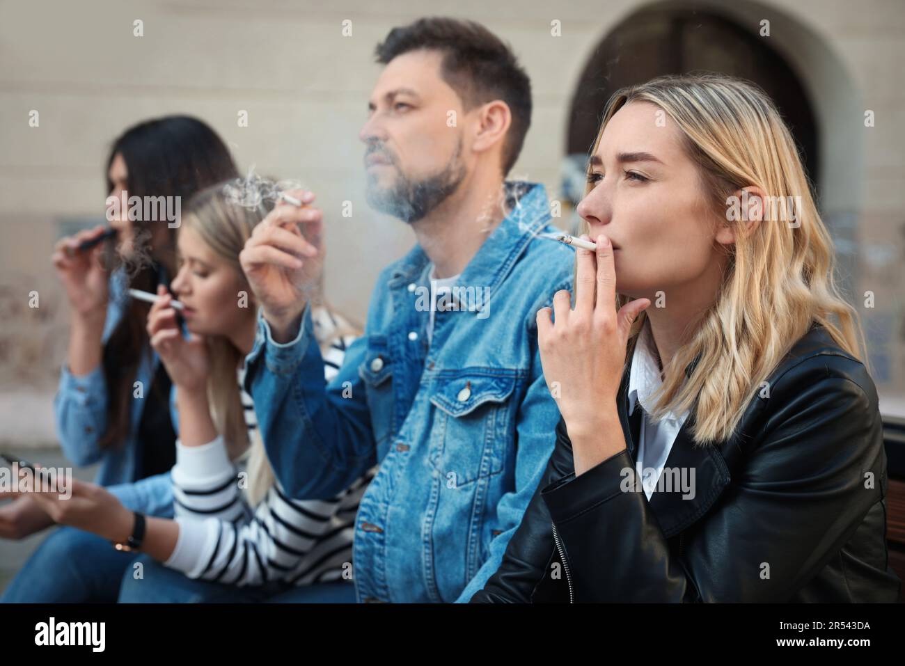 People smoking cigarettes at public place outdoors Stock Photo - Alamy