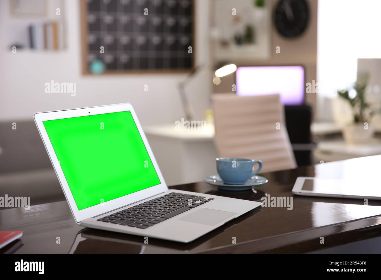 Laptop display with chroma key on desk in room. Comfortable workplace ...