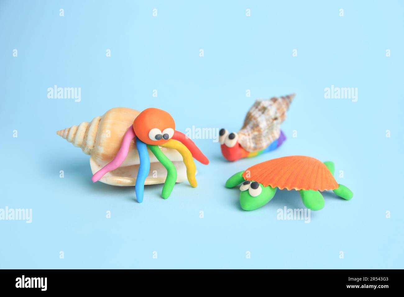 Turtle, snail and crab made from plasticine on light blue background ...