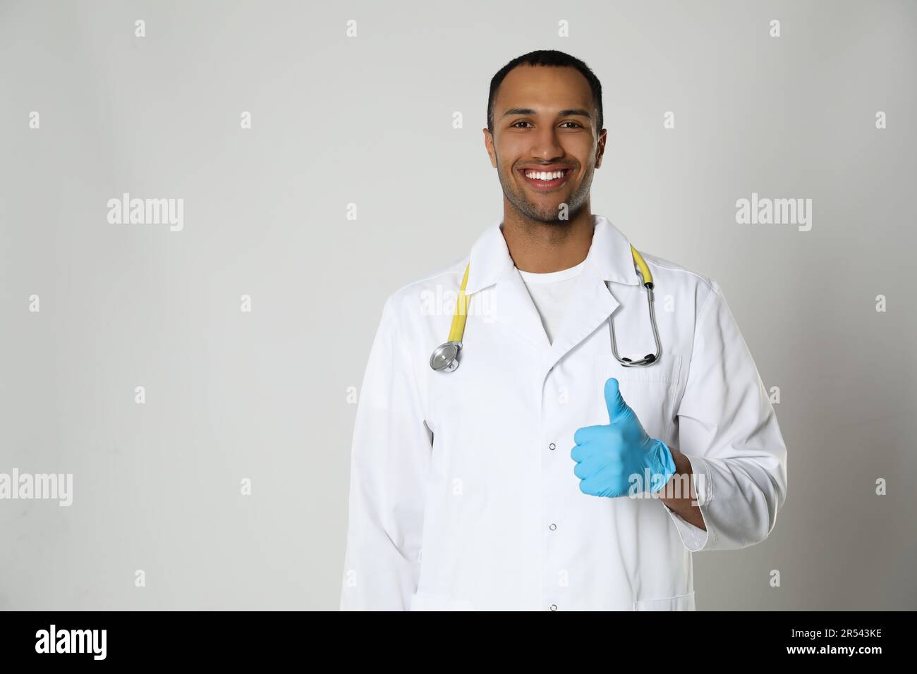 Doctor or medical assistant (male nurse) in uniform showing thumb up on ...