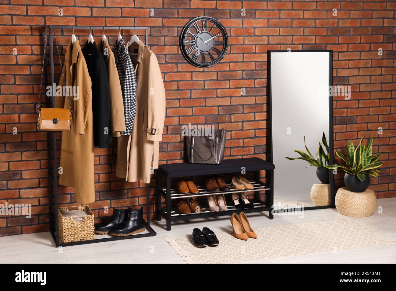 Stylish hallway with coat rack, mirror and shoe storage bench near ...