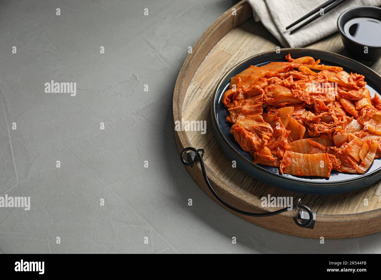 Delicious kimchi with Chinese cabbage and sauce on light grey table ...