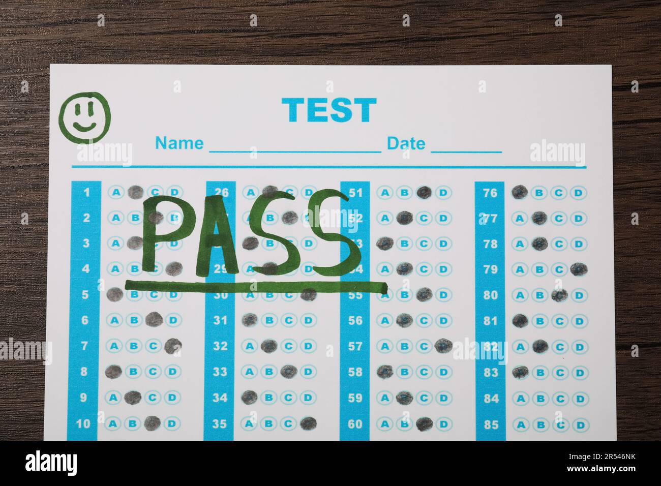 Answer sheet with word Pass on wooden table, top view. Student passing ...