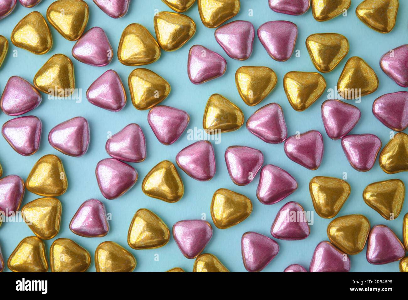 Many delicious heart shaped candies on light blue background, flat lay ...