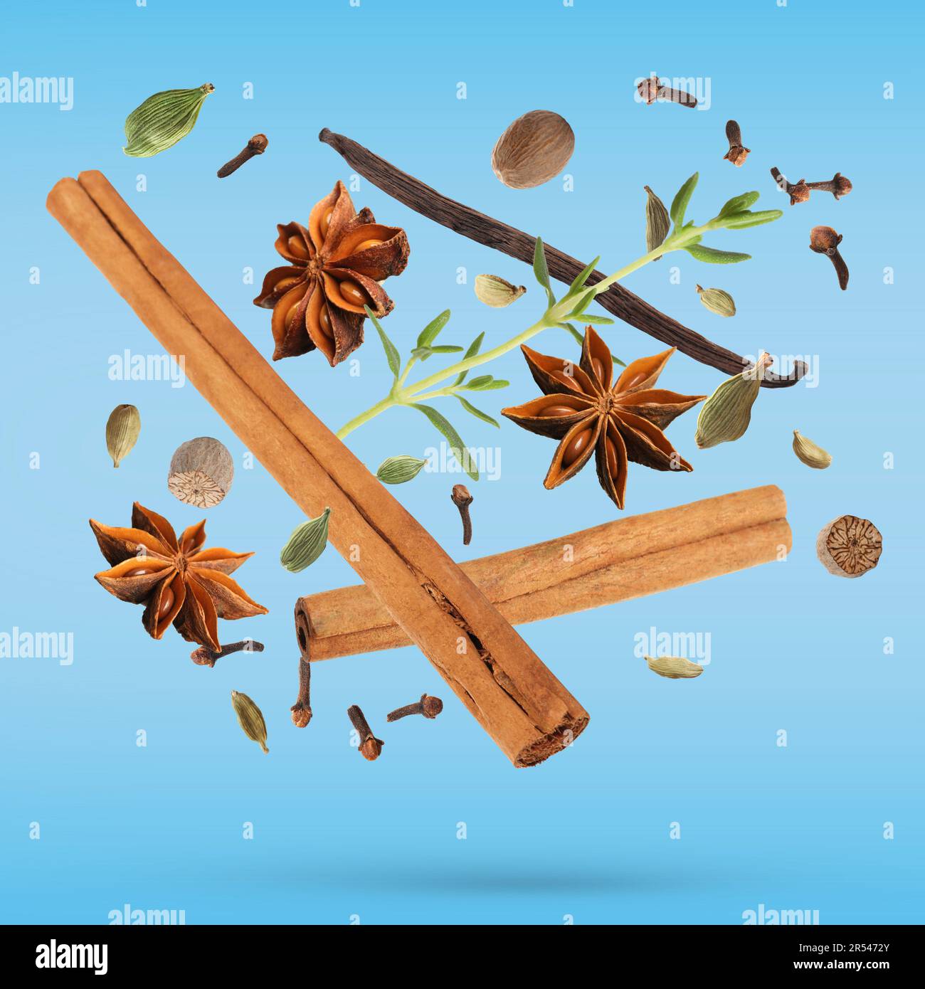 Many different spices falling on light blue background Stock Photo - Alamy