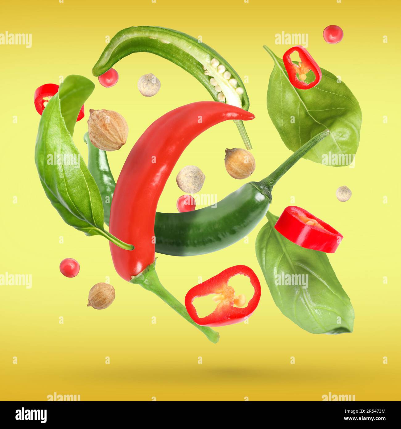 Many different spices falling on yellow background Stock Photo - Alamy