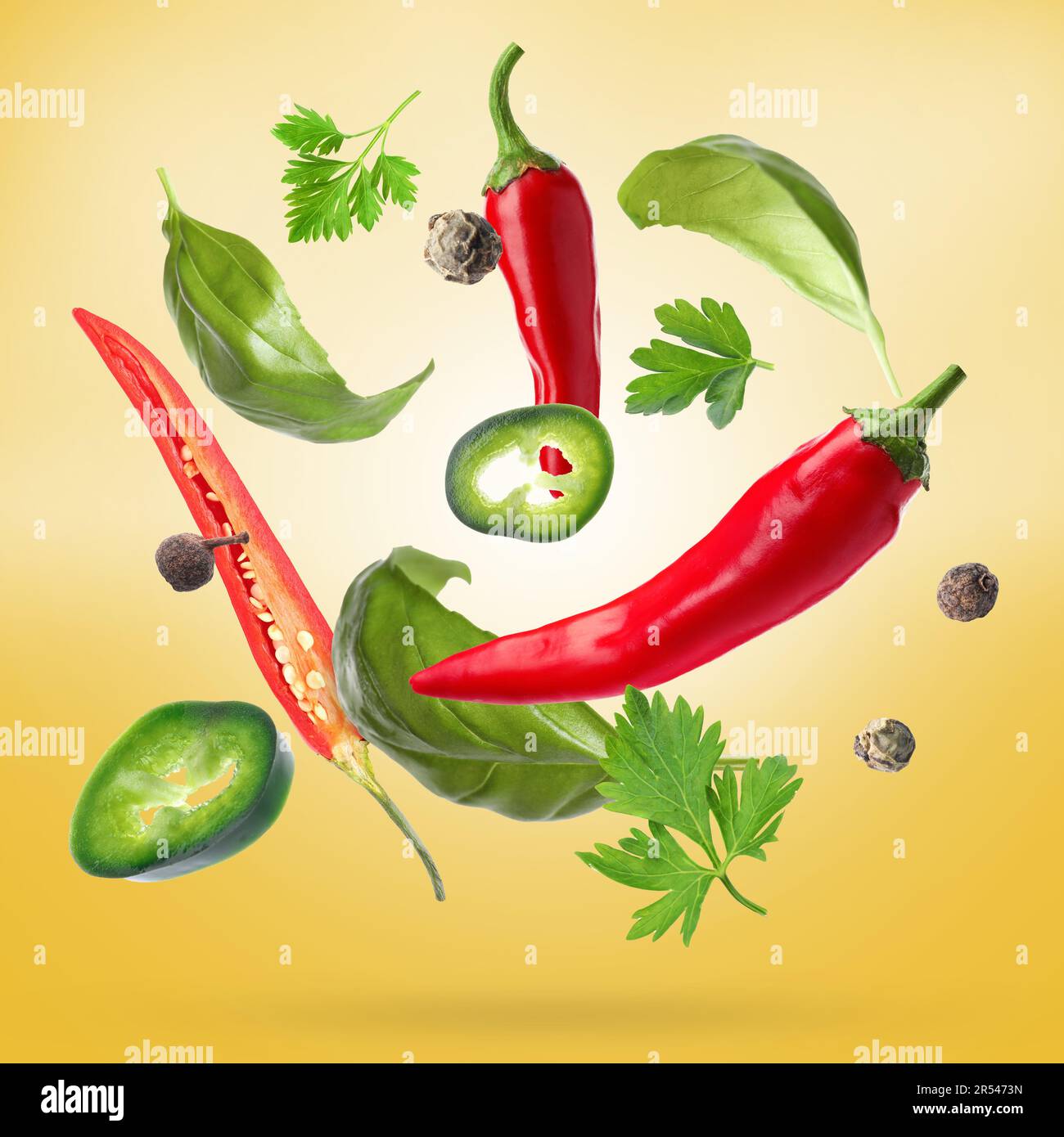 Many different spices falling on pale yellow background Stock Photo - Alamy