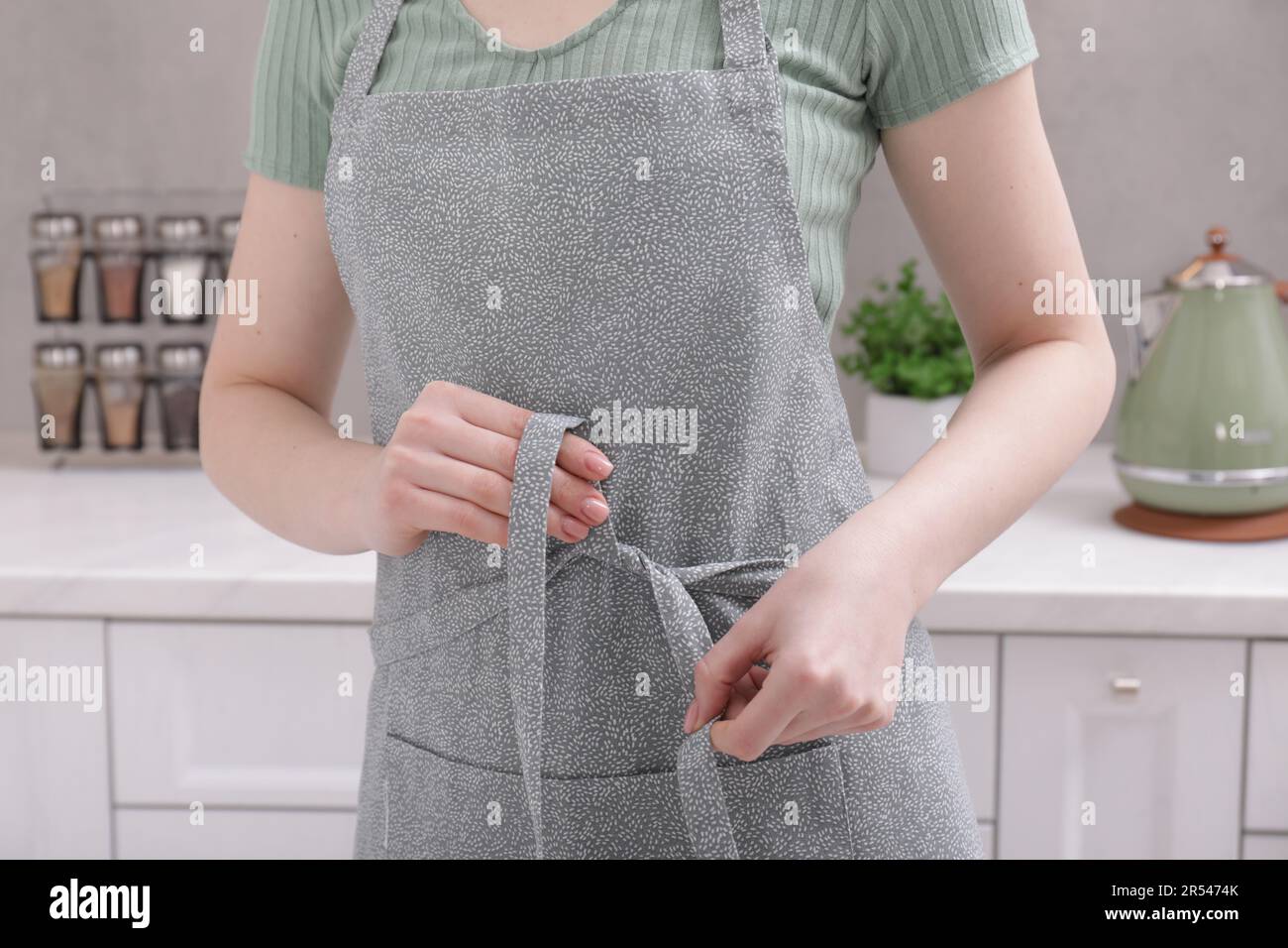 Woman putting on apron in hi-res stock photography and images - Alamy