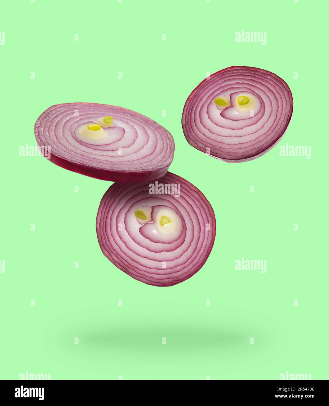 Fresh red onion slices falling on pale light green background Stock ...