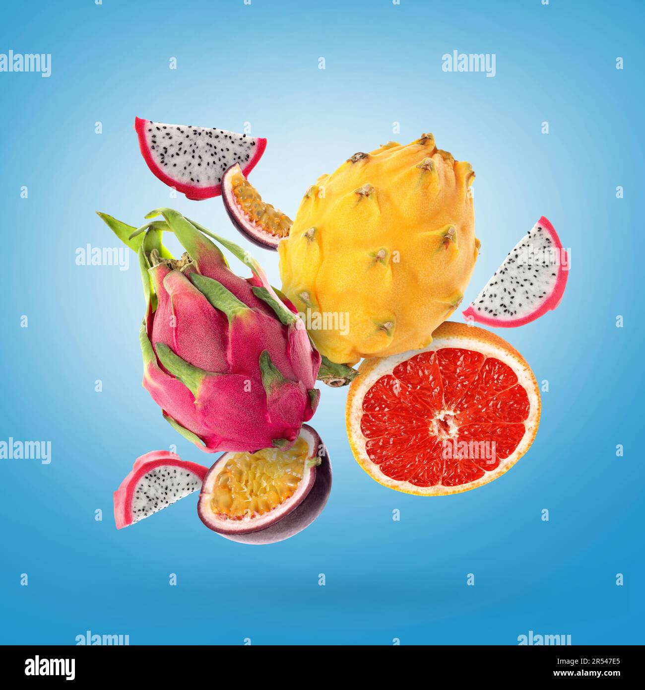 Many fresh tropical fruits falling on light blue background Stock Photo ...