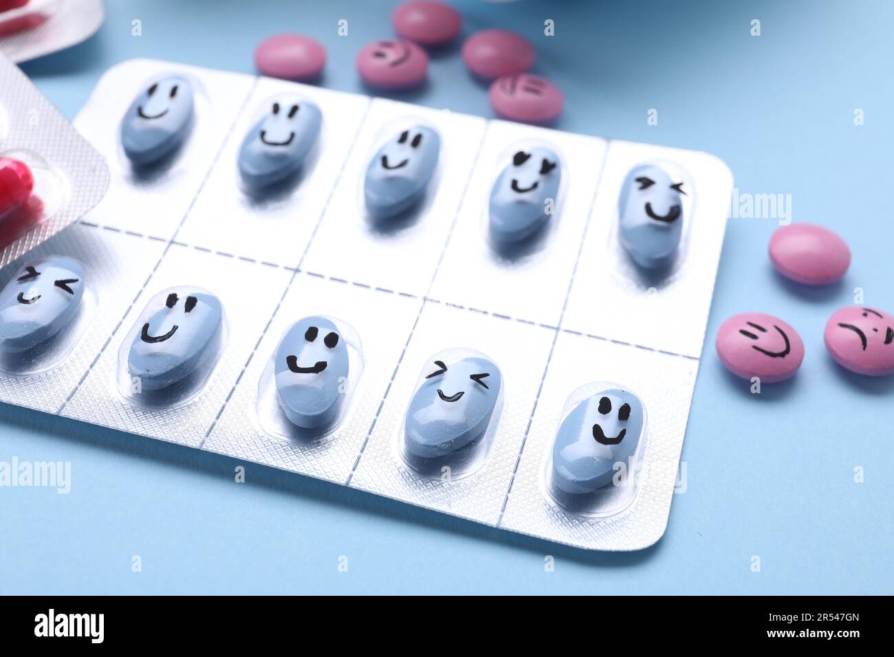 Blister and antidepressant pills with emotional faces on light blue ...