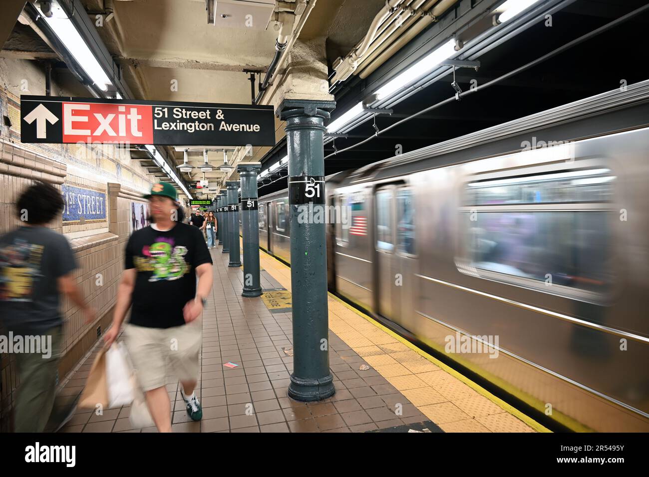 Riders exit the platform as a MTA subway train leaves the 51st Street station in New York City ...