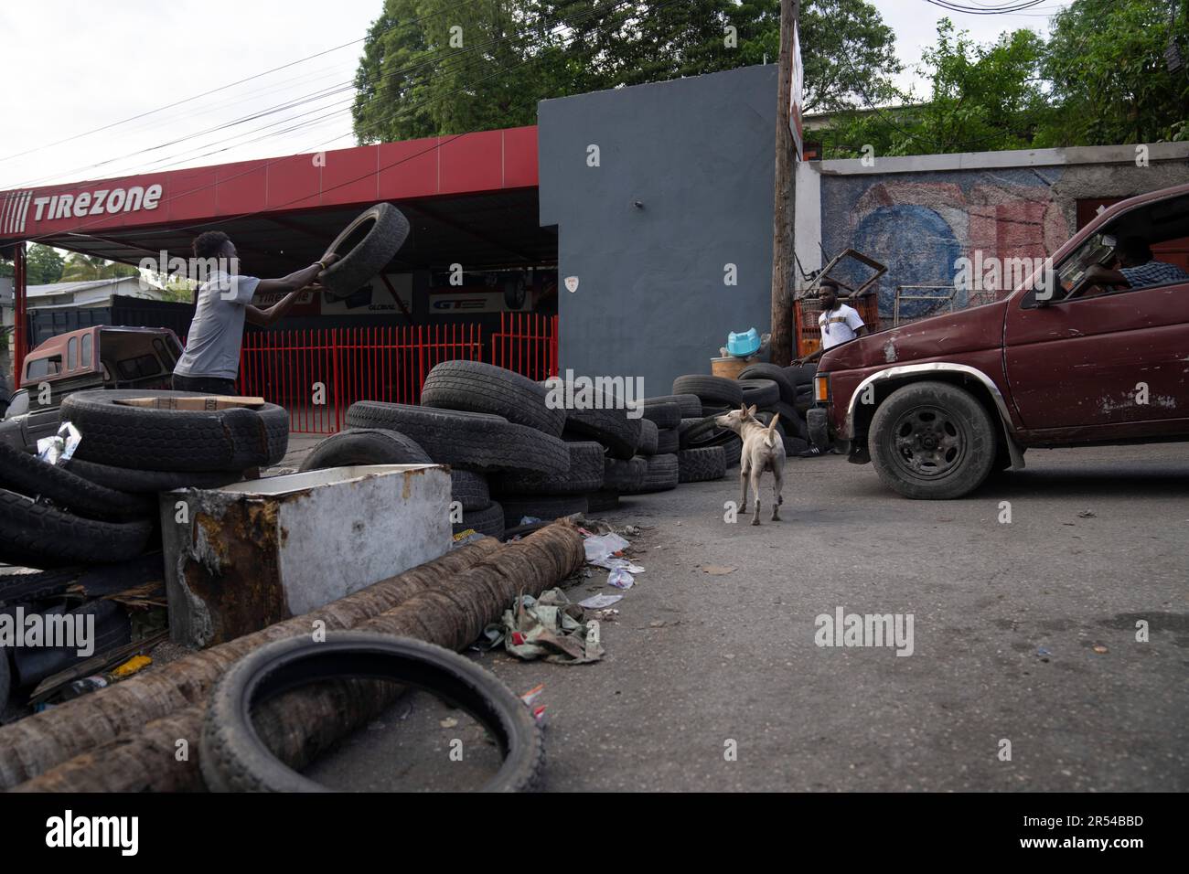 A man throws a tire to make a barricade to close a street at 6:00 pm as ...