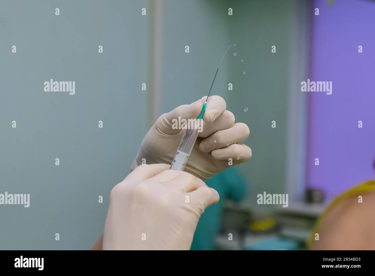 Doctor fills syringe with medication while preparing to administer ...