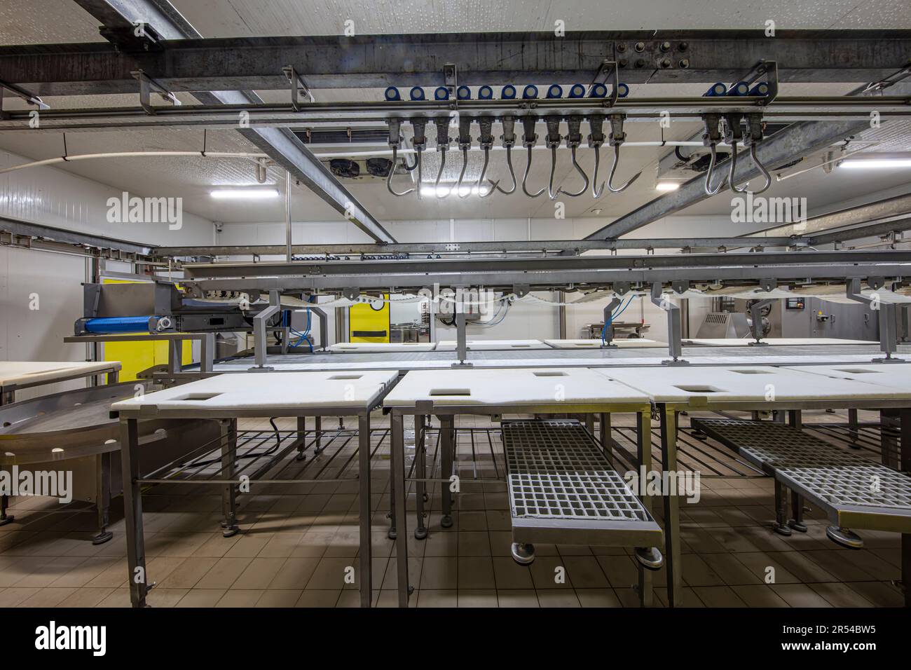 Meat processing machines at meat factory. Cutting meat in ...